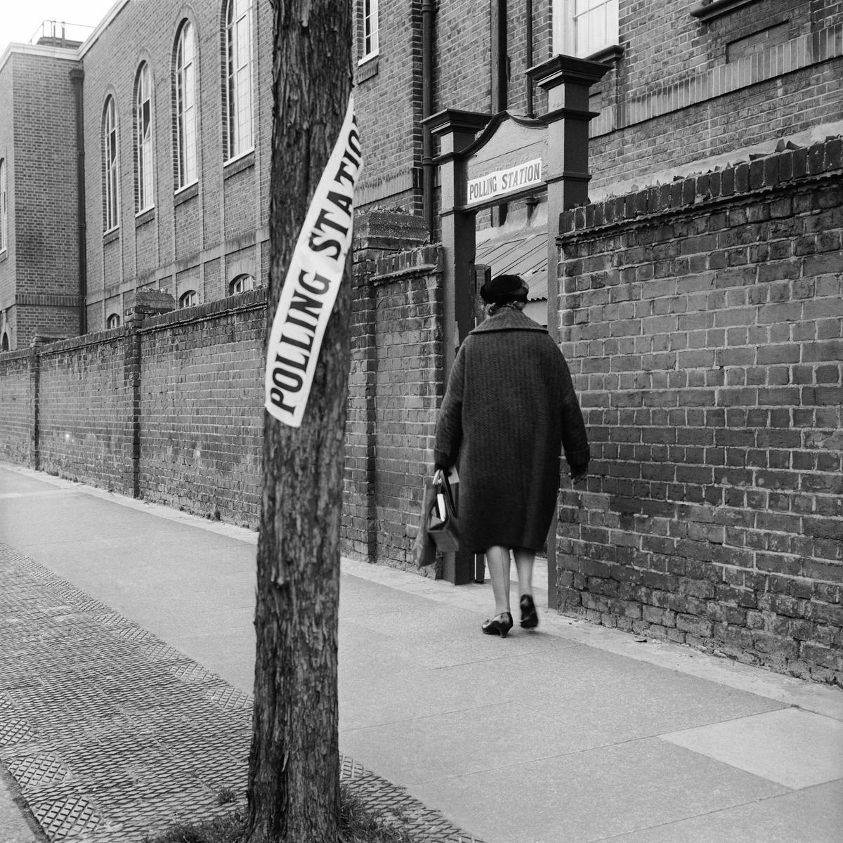 A woman entering a polling station during the General election of 1959 ...