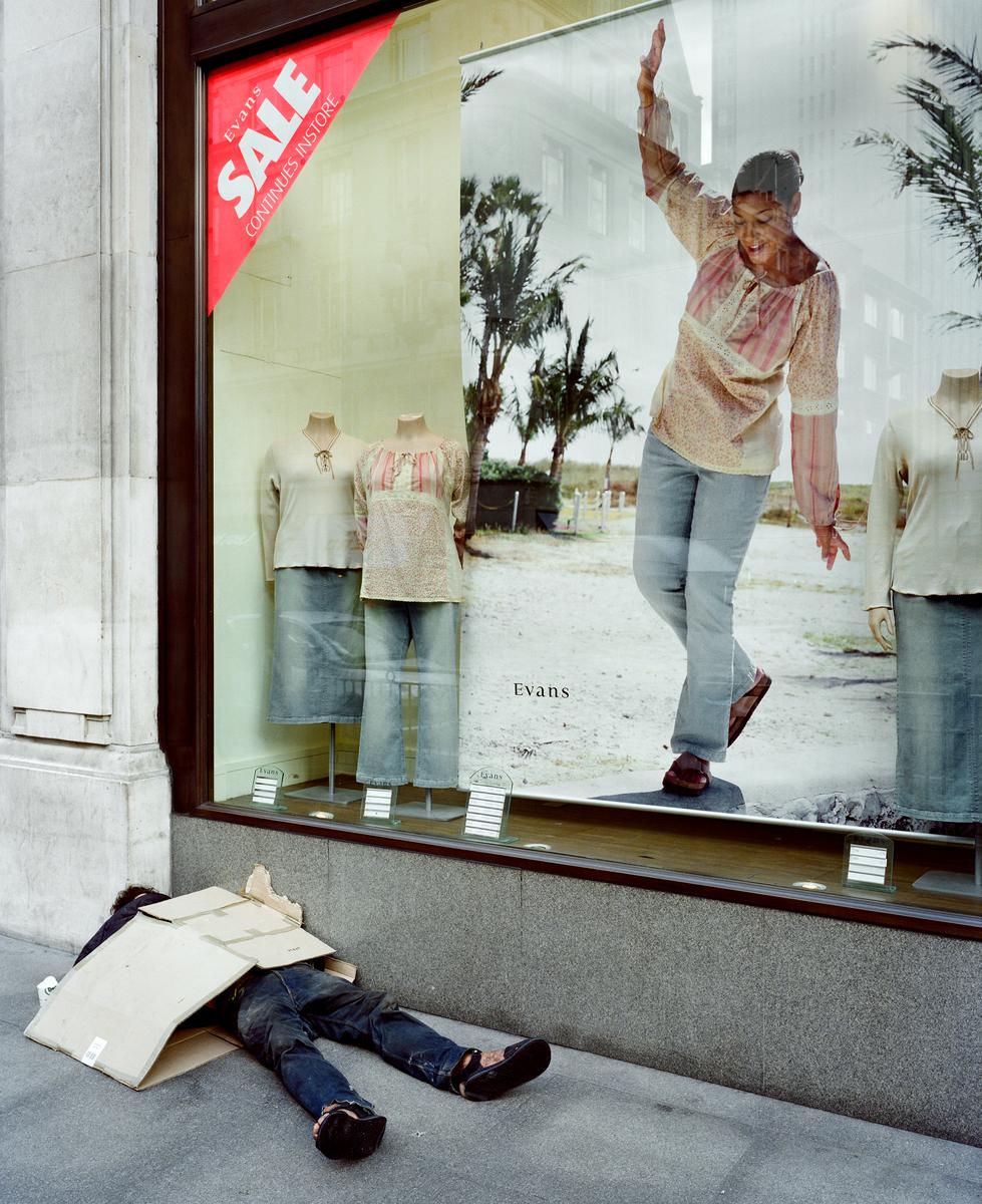 A homeless man outside a shop on Oxford Street, sleeping under a ...